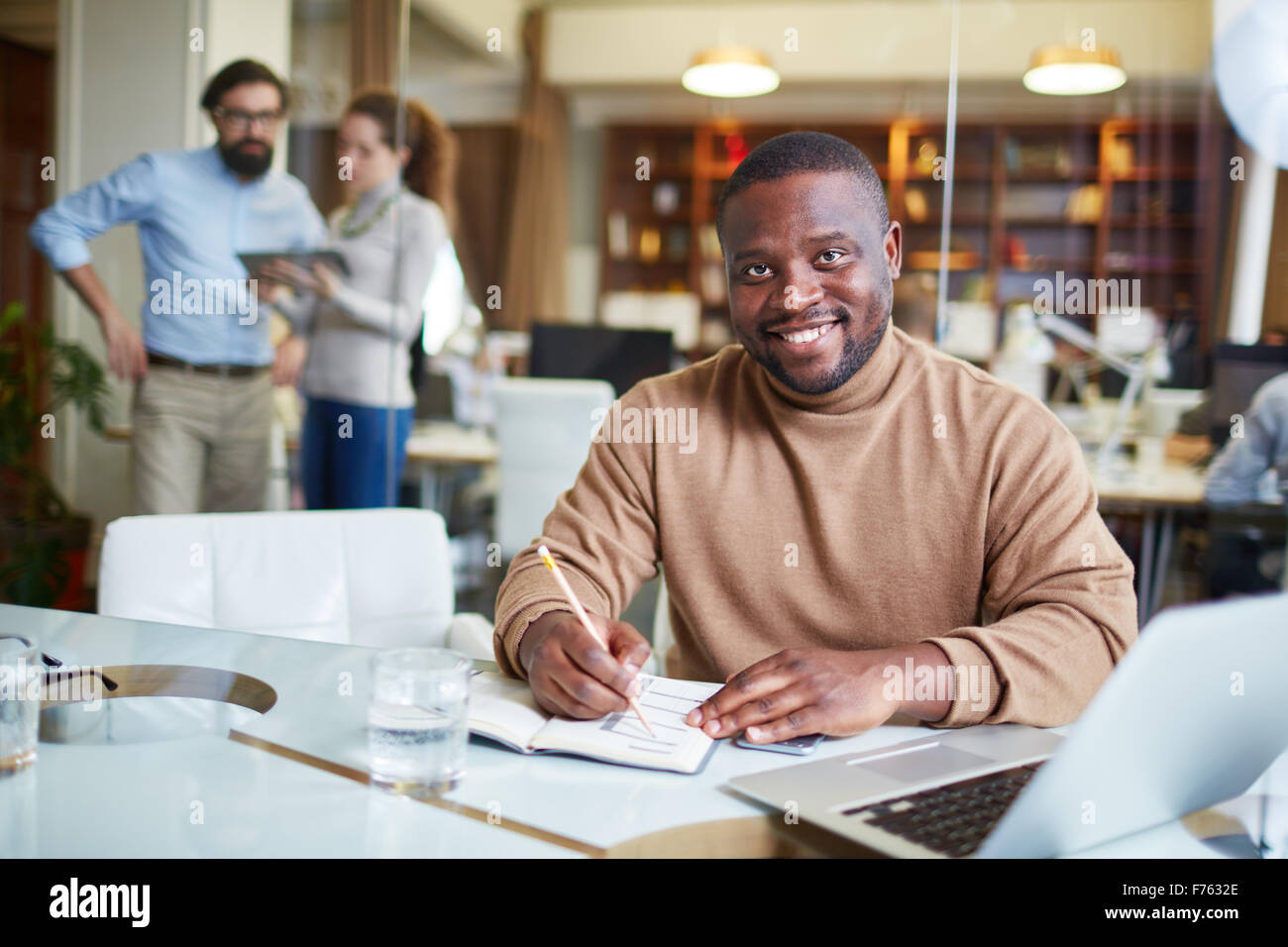 Happy African-American employee working in office Stock Photo - Alamy