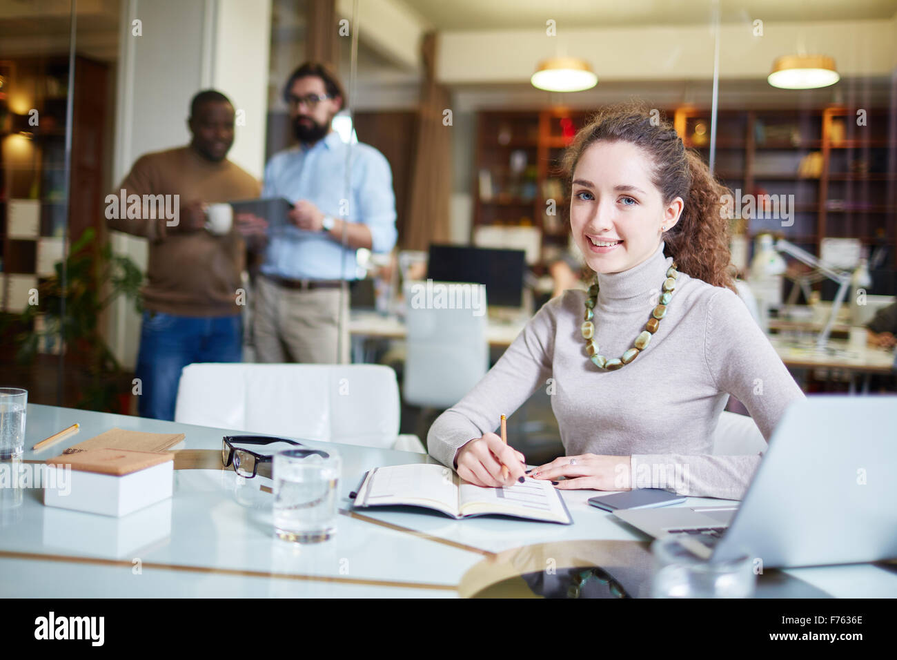 Young employee looking at camera at workplace Stock Photo - Alamy