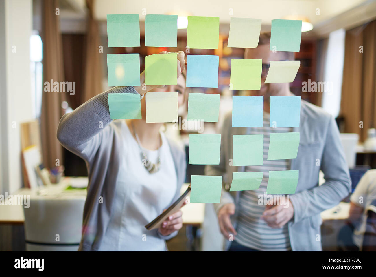 Employees reading working points and making notes on reminders in ...