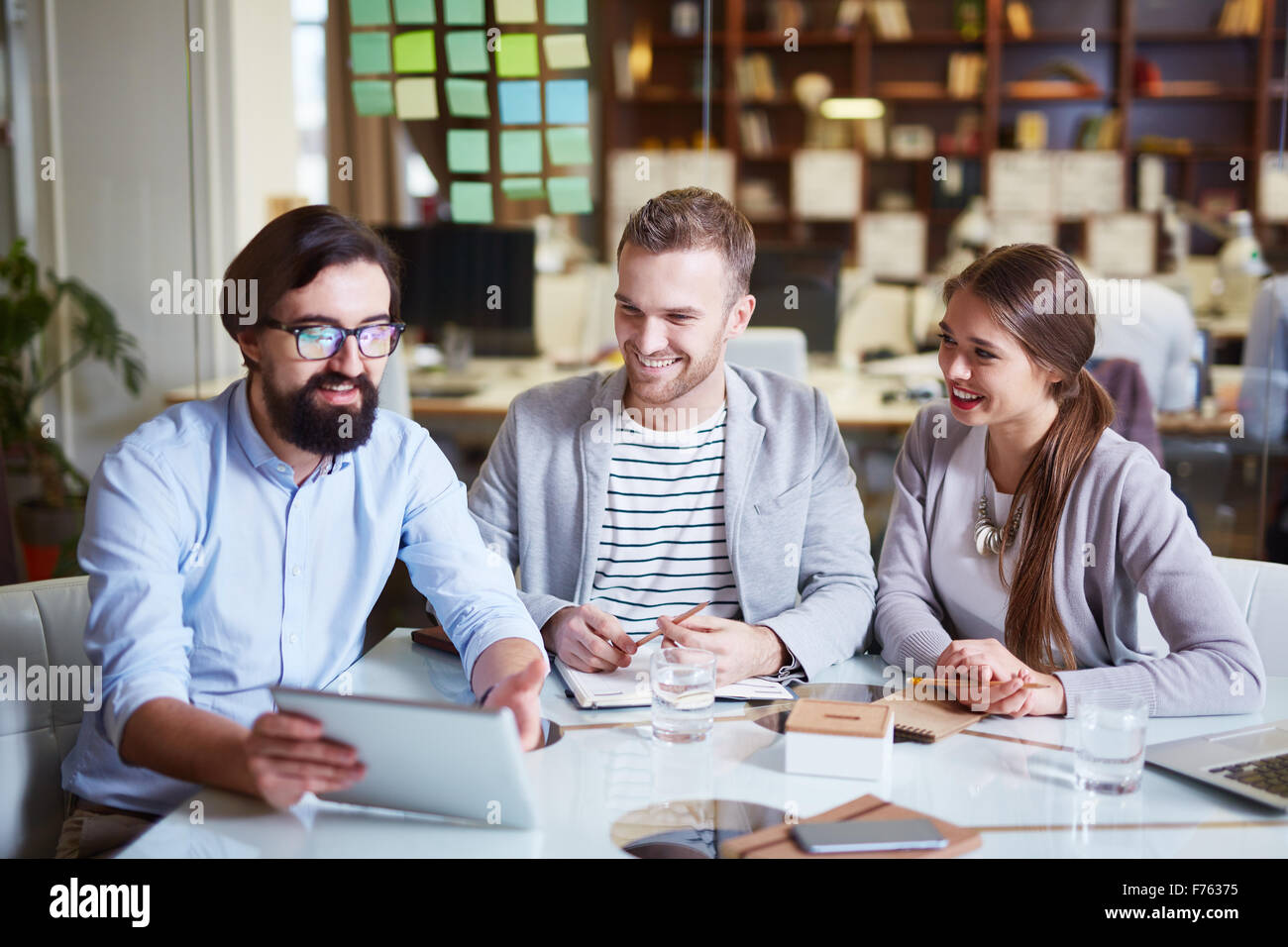 Modern businessman with touchpad explaining data to co-workers Stock ...
