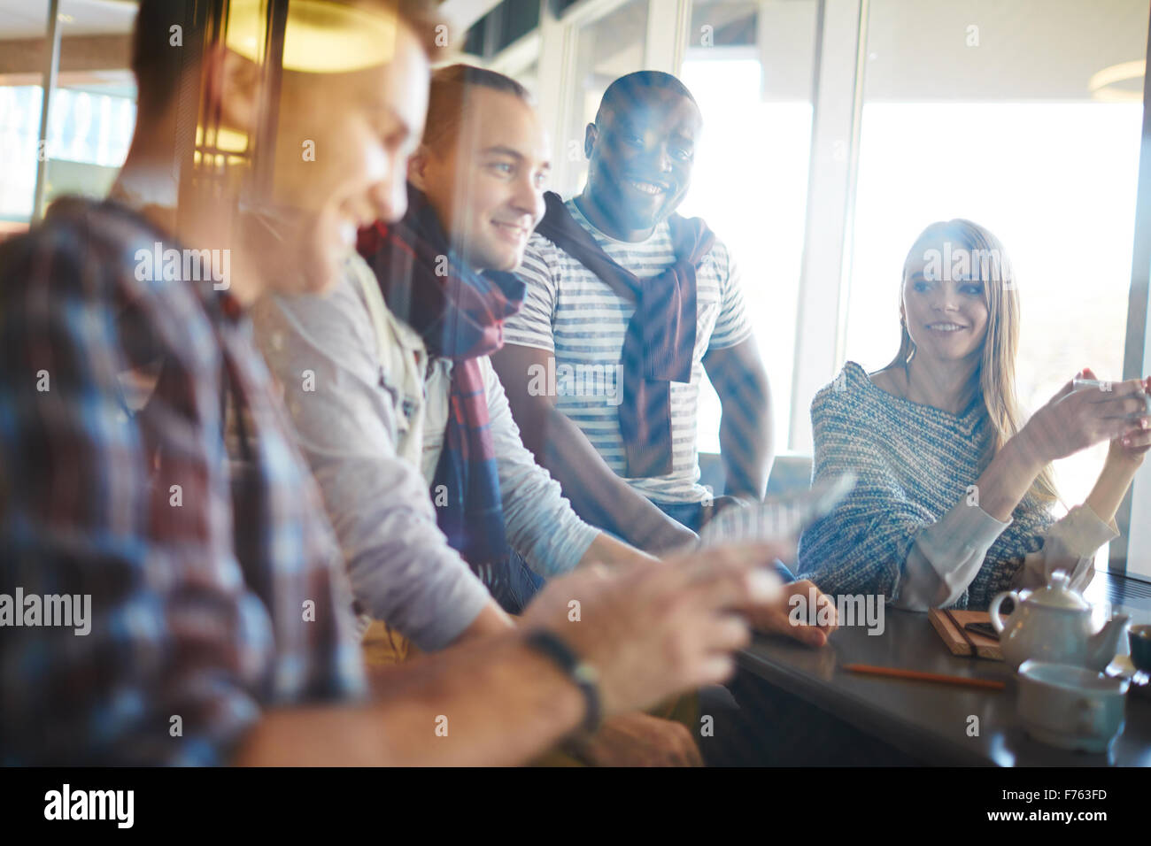 Several young friends sitting in cafe at leisure Stock Photo - Alamy