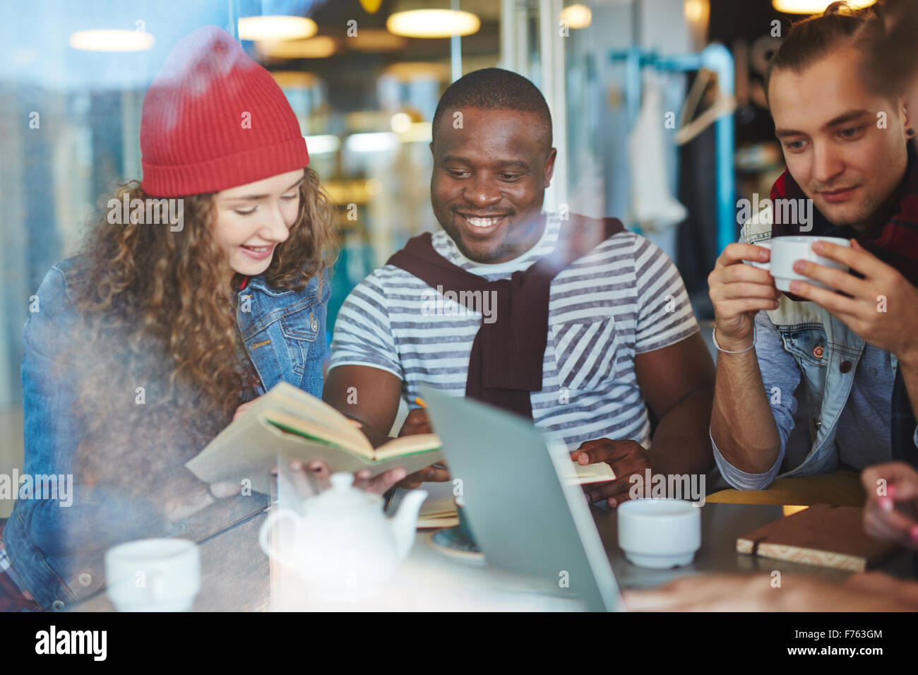 Teenage friends with books reading homework in cafe Stock Photo - Alamy