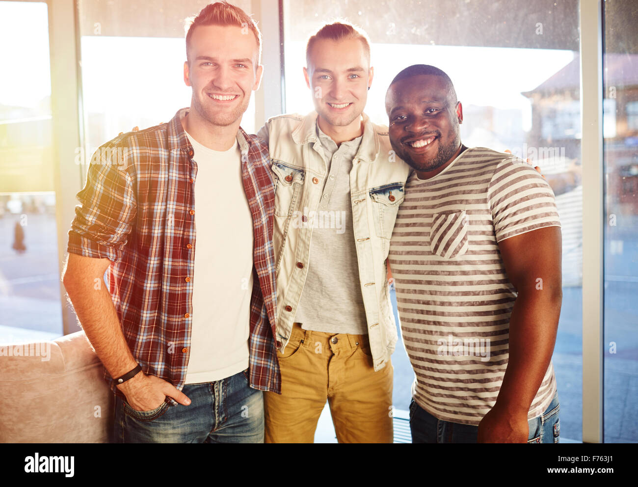 Group of friendly guys in casual-wear looking at camera Stock Photo - Alamy