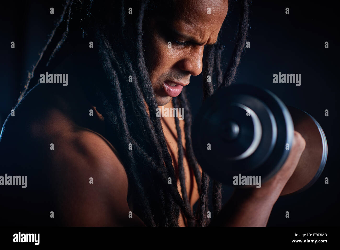 Young sporty man with barbell pumping arm muscles Stock Photo - Alamy