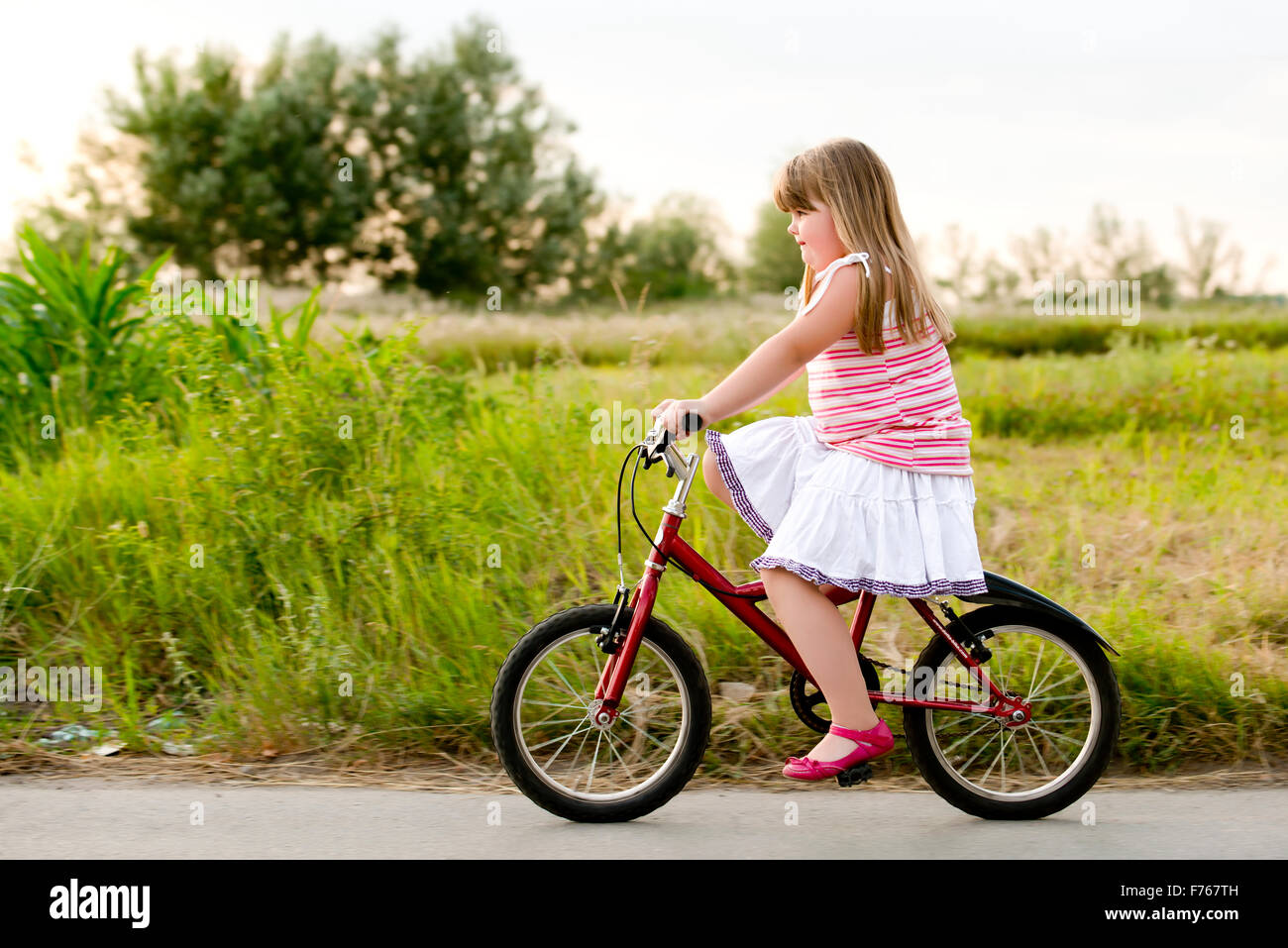 little girl enjoys riding a bike Stock Photo - Alamy