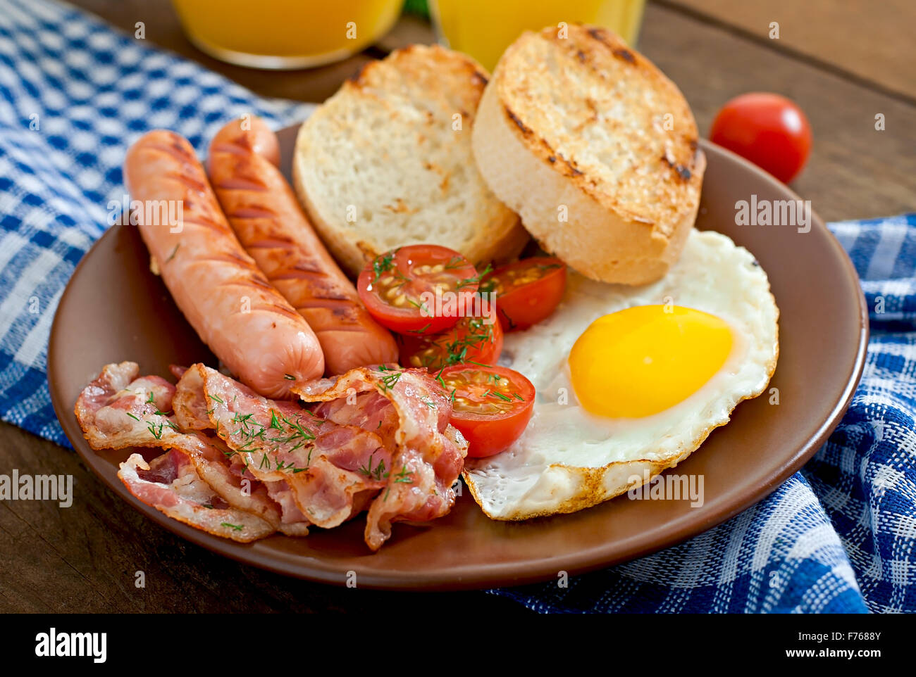 English breakfast - toast, egg, bacon and vegetables in a rustic style ...
