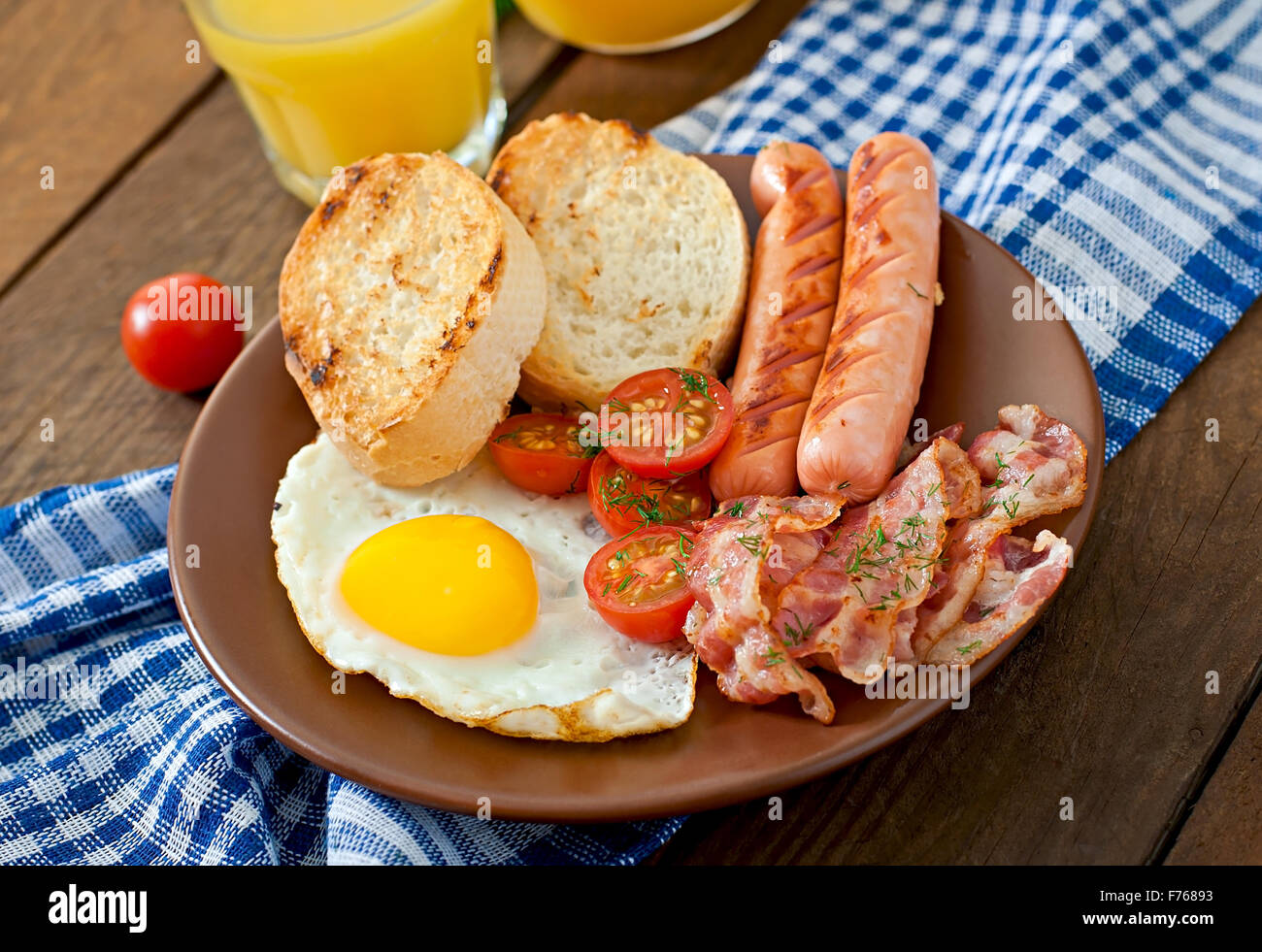 English breakfast - toast, egg, bacon and vegetables in a rustic style ...