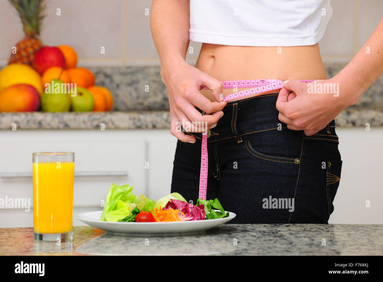 woman eating salad and fruits and measuring her waist Stock Photo - Alamy