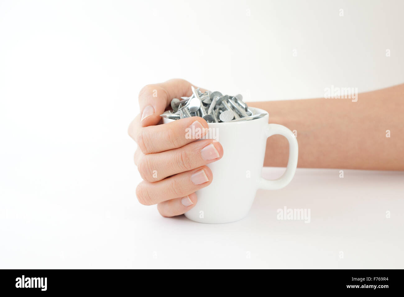 Woman cradles a Cup of Nails in a Coffee Cup Stock Photo - Alamy