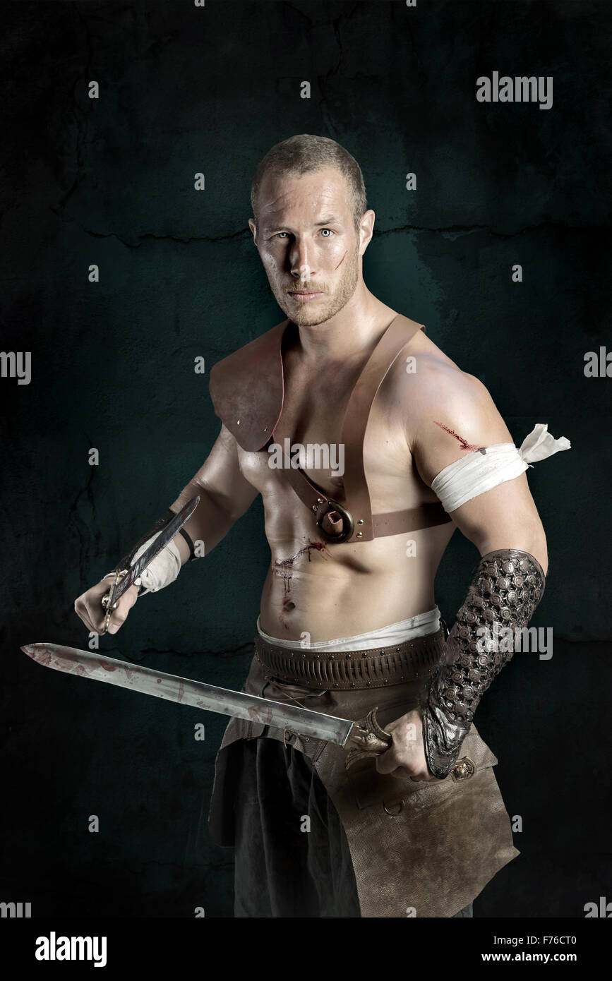 Gladiator posing isolated in a dark background Stock Photo - Alamy