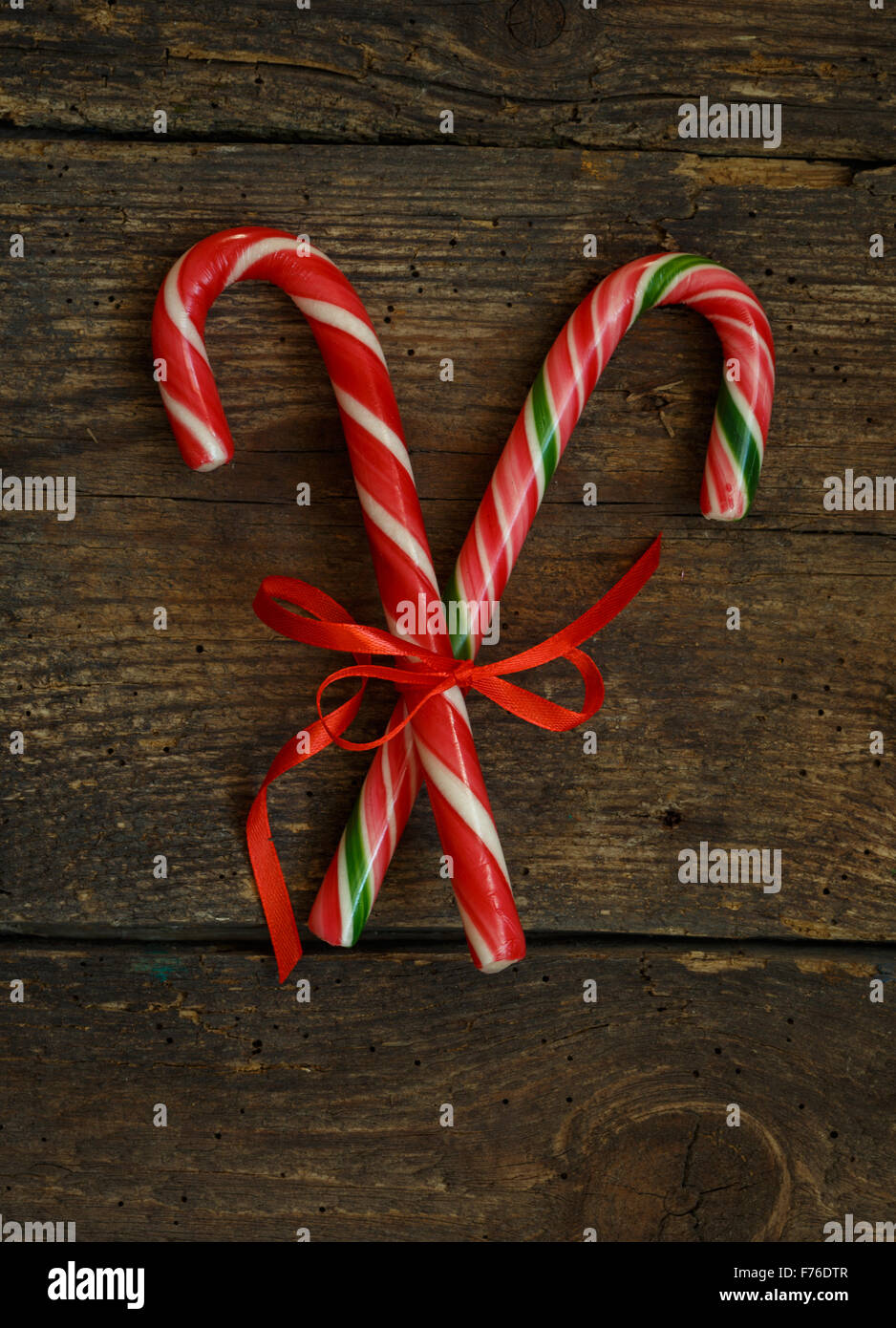 Closeup of two old fashioned candy canes on a rustic wooden background ...