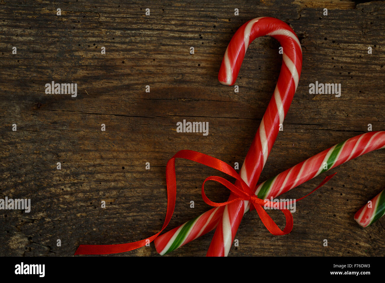 Closeup of two old fashioned candy canes on a rustic wooden background ...