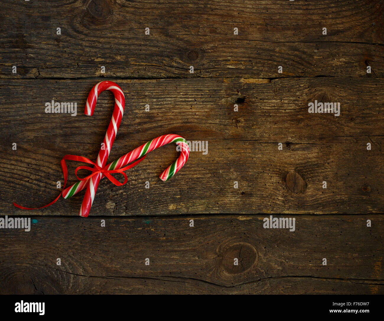 Closeup of two old fashioned candy canes on a rustic wooden background ...