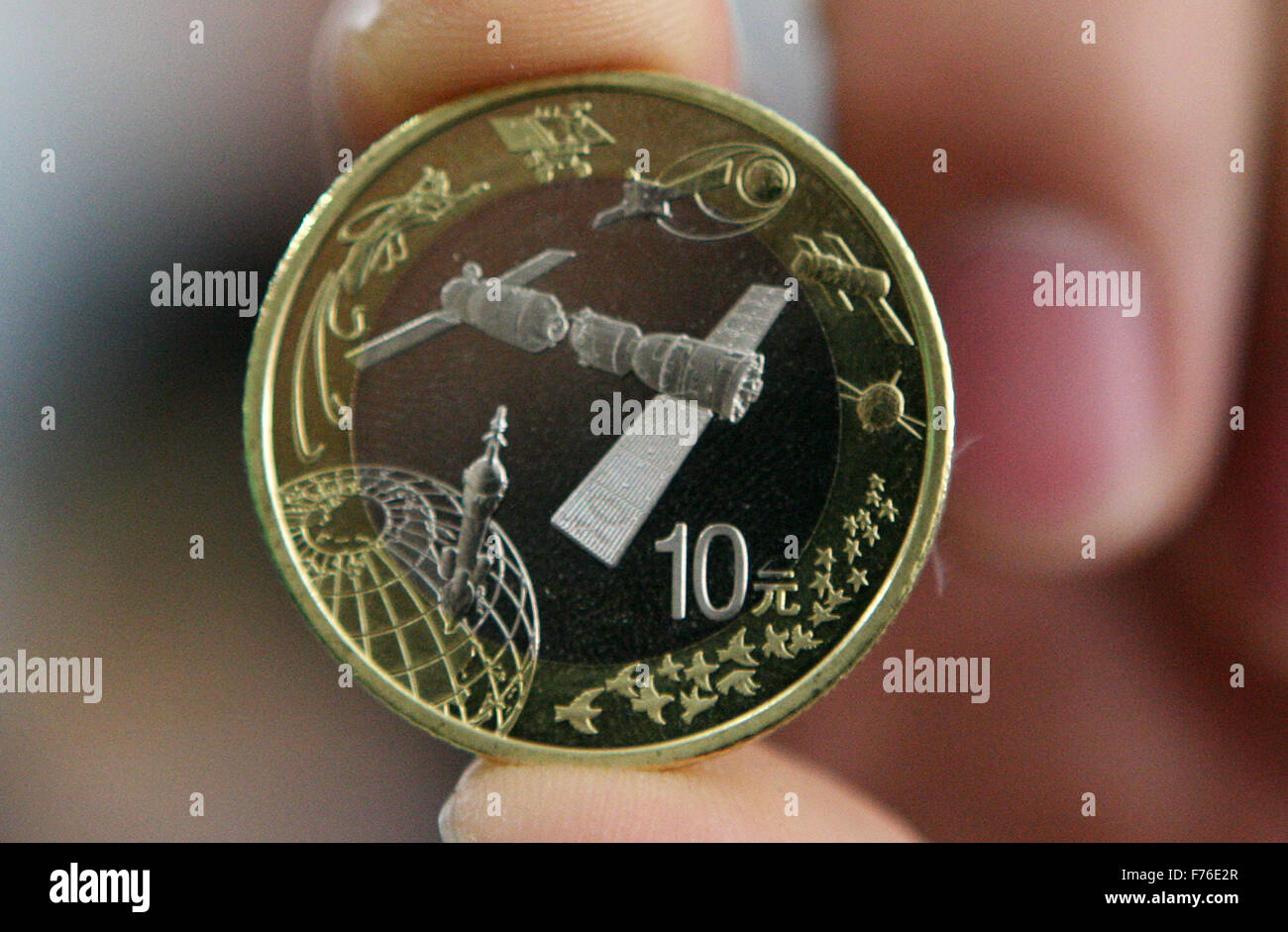 Beijing, China. 26th Nov, 2015. A resident shows a commemorative coin ...