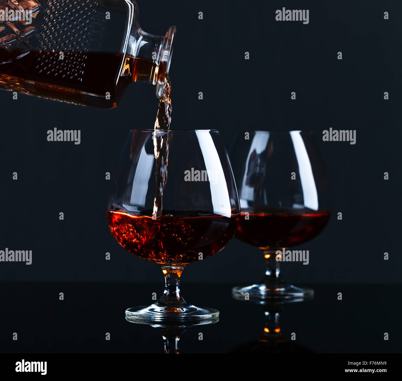 Snifter with brandy on a black background Stock Photo - Alamy