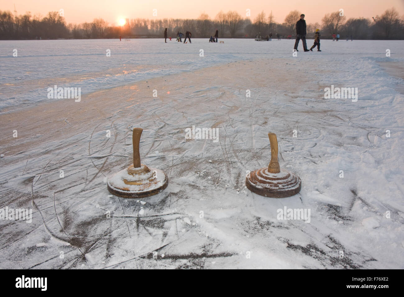 two curling stones on a frozen lake at sunset Stock Photo - Alamy