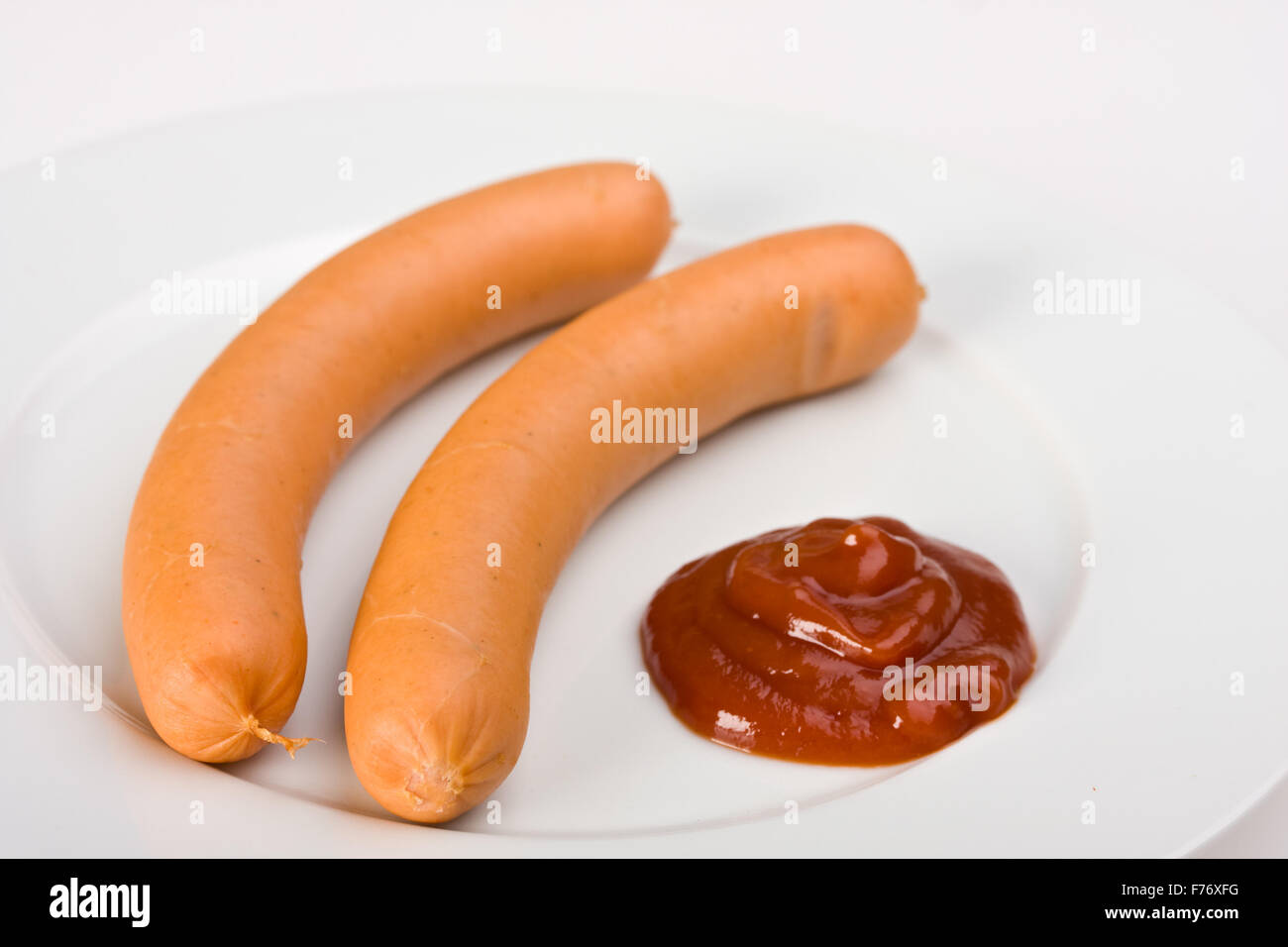 a pair of wieners on a white plate Stock Photo - Alamy