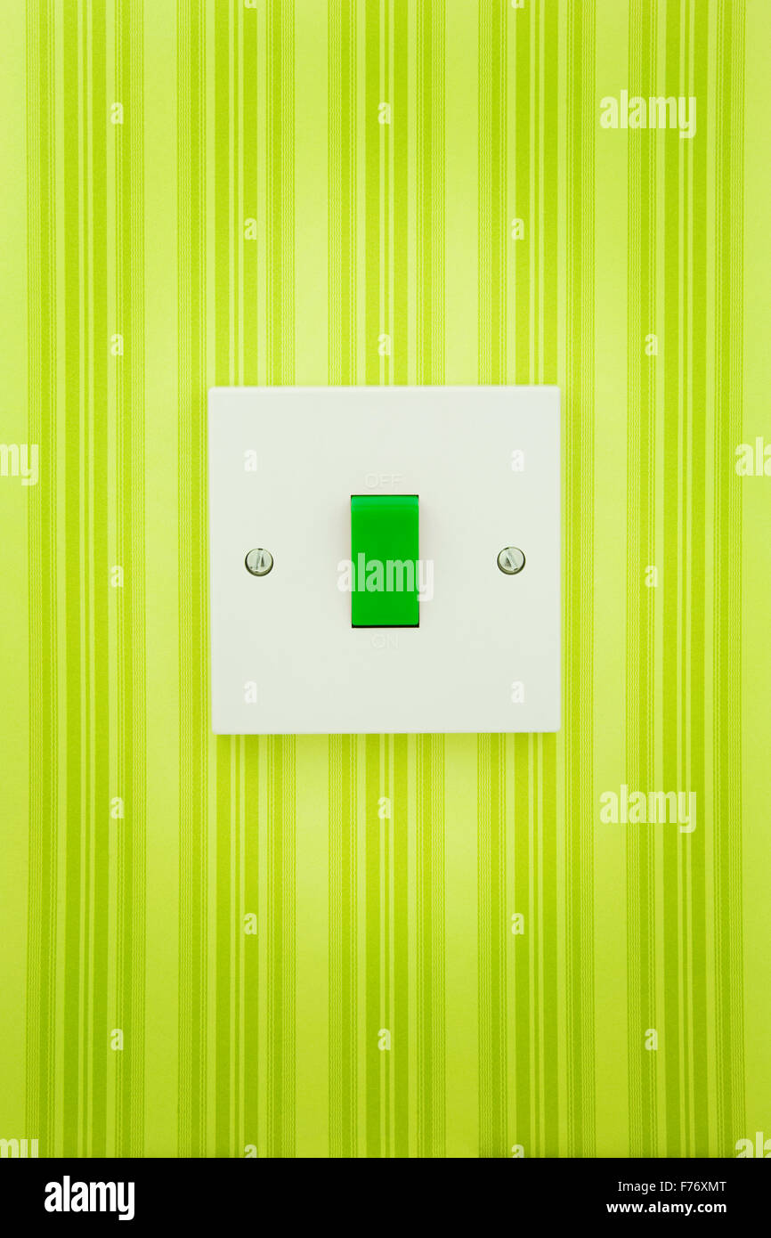 Green Switch on a white socket with a stripy wall paper backgr Stock ...