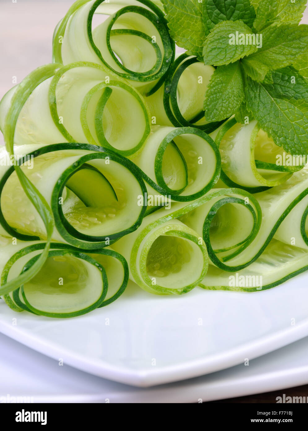 Salad cucumber ribbons twisted in rolls with mint Stock Photo - Alamy