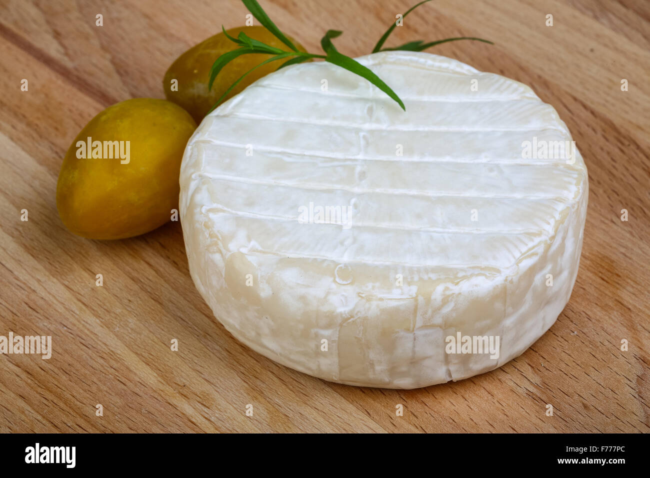 Round Brie cheese with yellow plums and estragon Stock Photo - Alamy