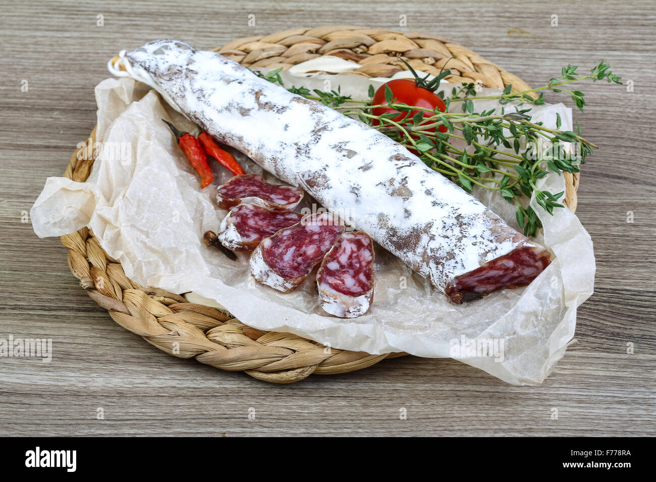 Traditional Spanish sausages- fuet with thyme leaves on the wood ...