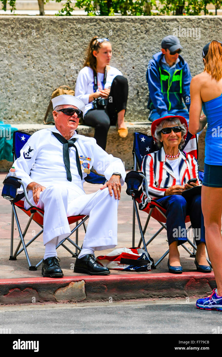WW2 US Navy veteran with his wife sit on the sidewalk and watch the ...