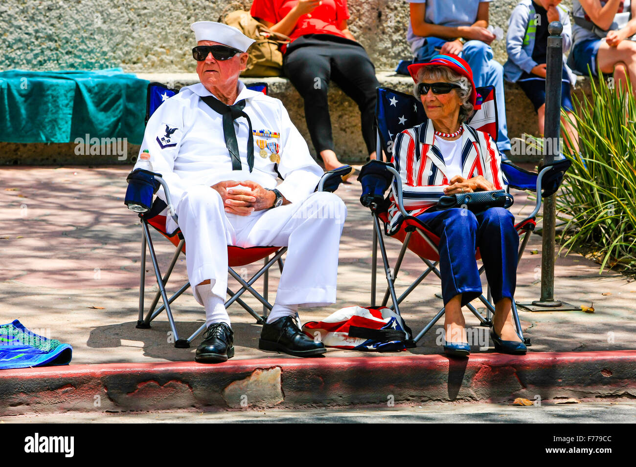 WW2 US Navy veteran with his wife sit on the sidewalk and watch the ...