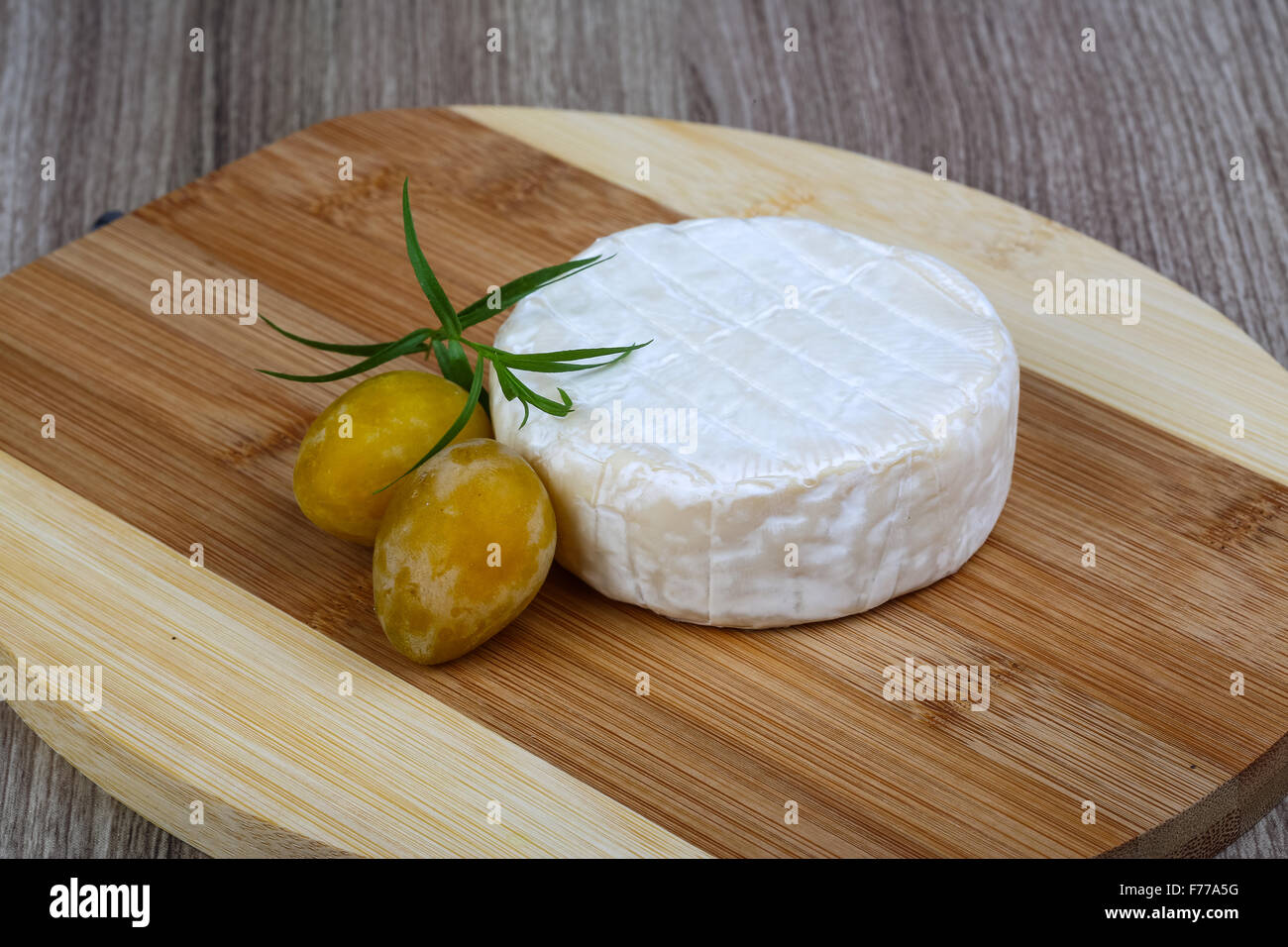 Round Brie cheese with yellow plums and estragon Stock Photo - Alamy