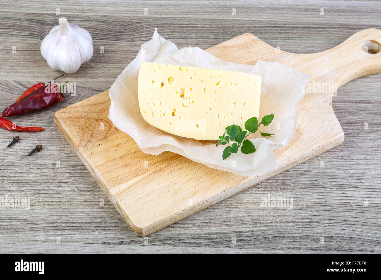 Part of round cheese on the wood background with herbs Stock Photo - Alamy
