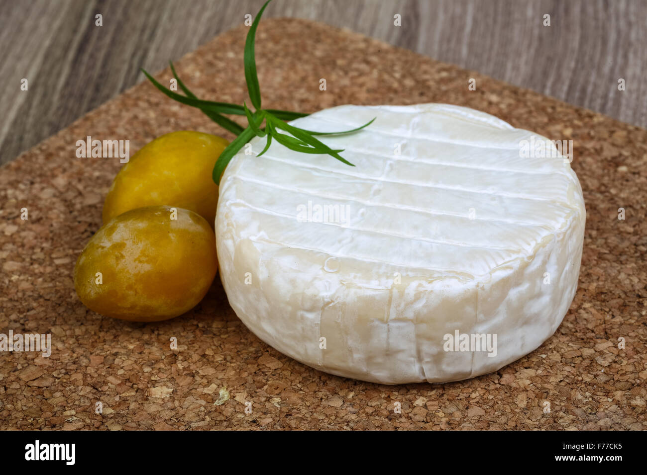 Round Brie cheese with yellow plums and estragon Stock Photo - Alamy