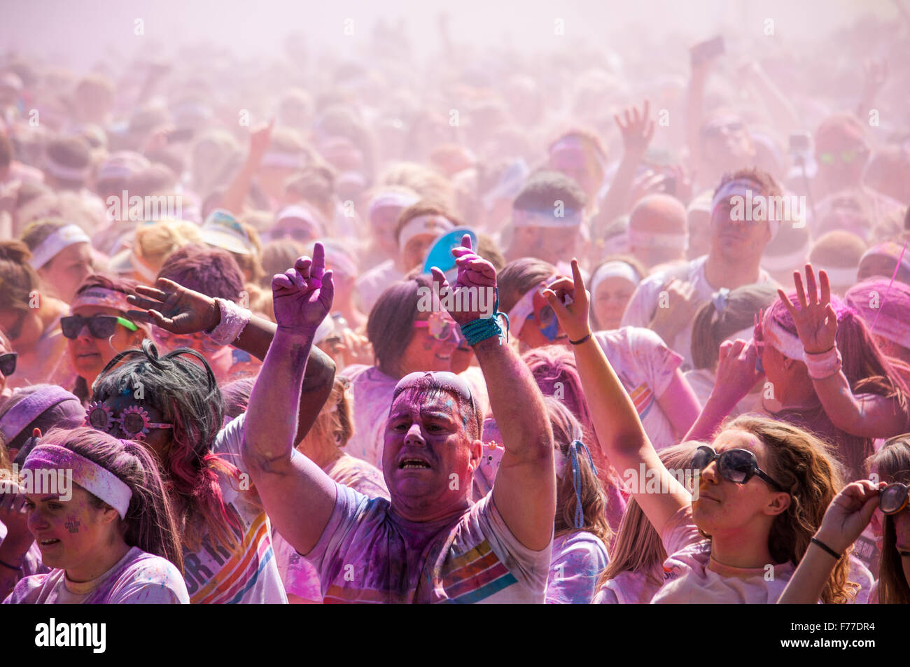 Color runners, covered in paint powder, after finishing the race Stock ...