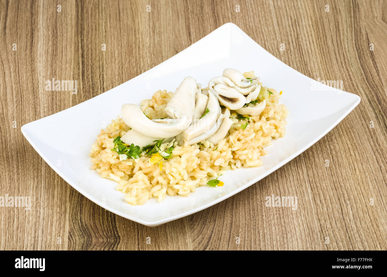 Risotto with calamari, parsley, garlik and lemon Stock Photo - Alamy