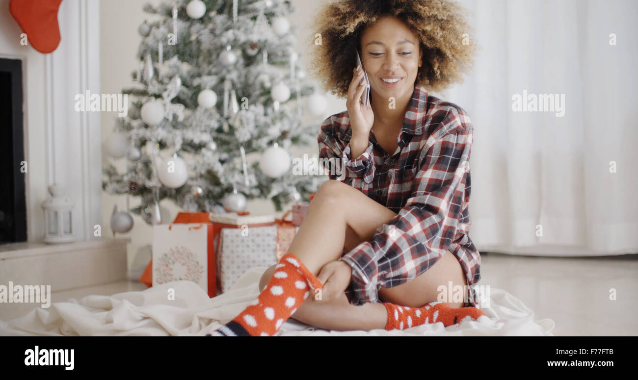 Young woman relaxing in front of a Christmas tree Stock Photo - Alamy