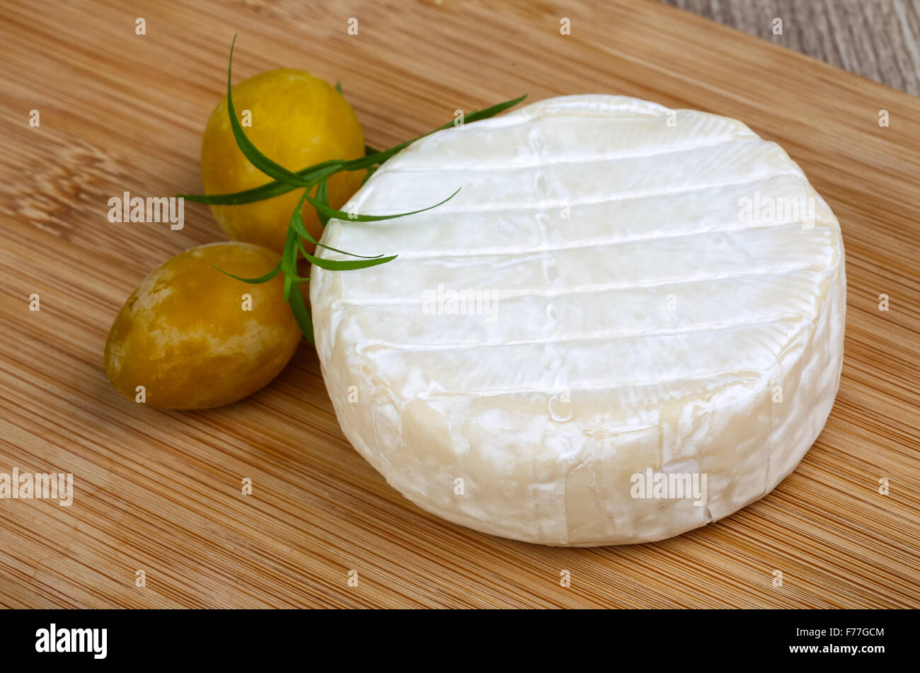 Round Brie cheese with yellow plums and estragon Stock Photo - Alamy