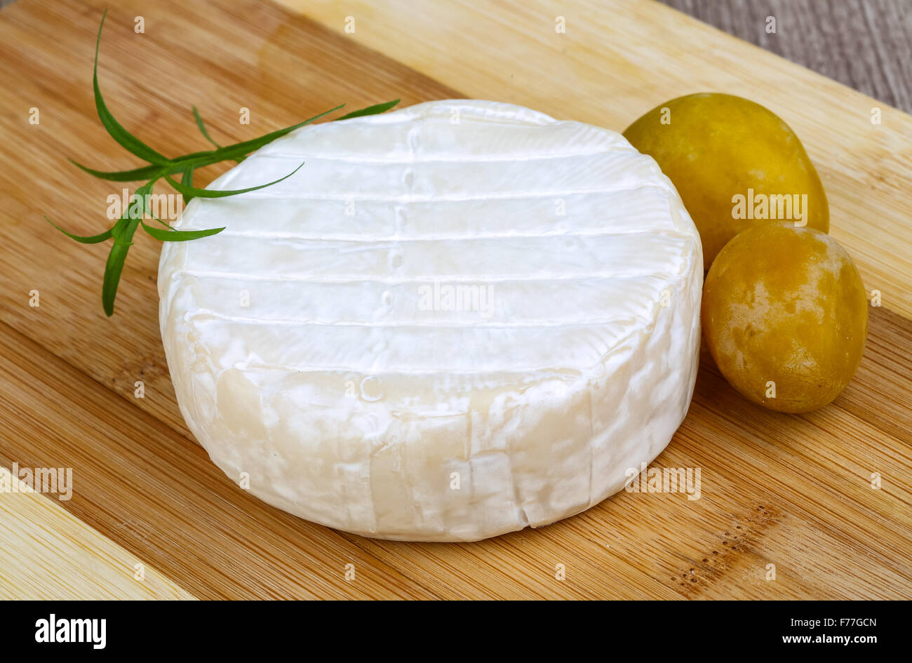 Round Brie cheese with yellow plums and estragon Stock Photo - Alamy