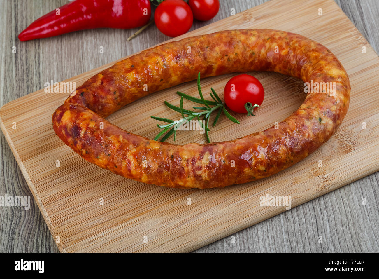 Sausage ring with rosemary and pepper on the wood background Stock ...