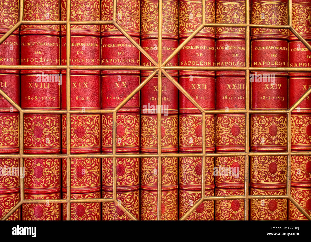 Collection of antique books in red leather with gold titles on the ...