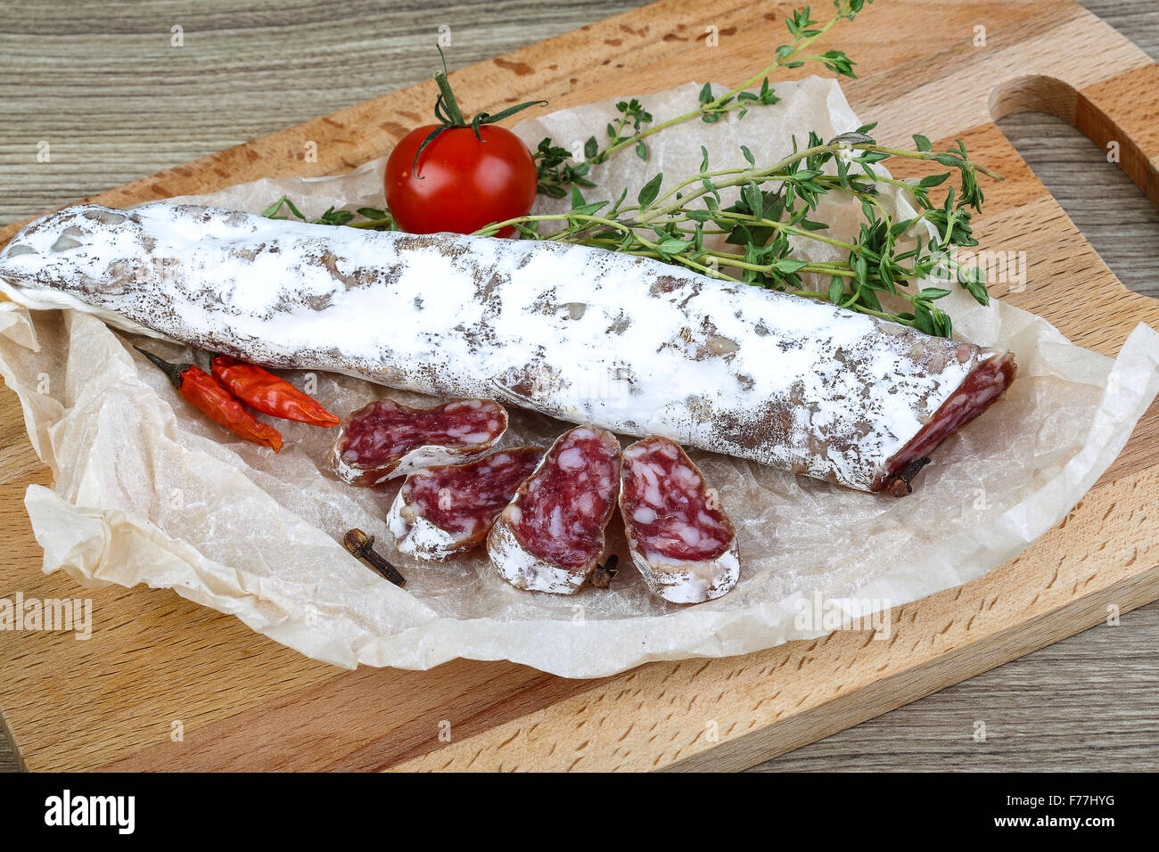 Traditional Spanish sausages- fuet with thyme leaves on the wood ...