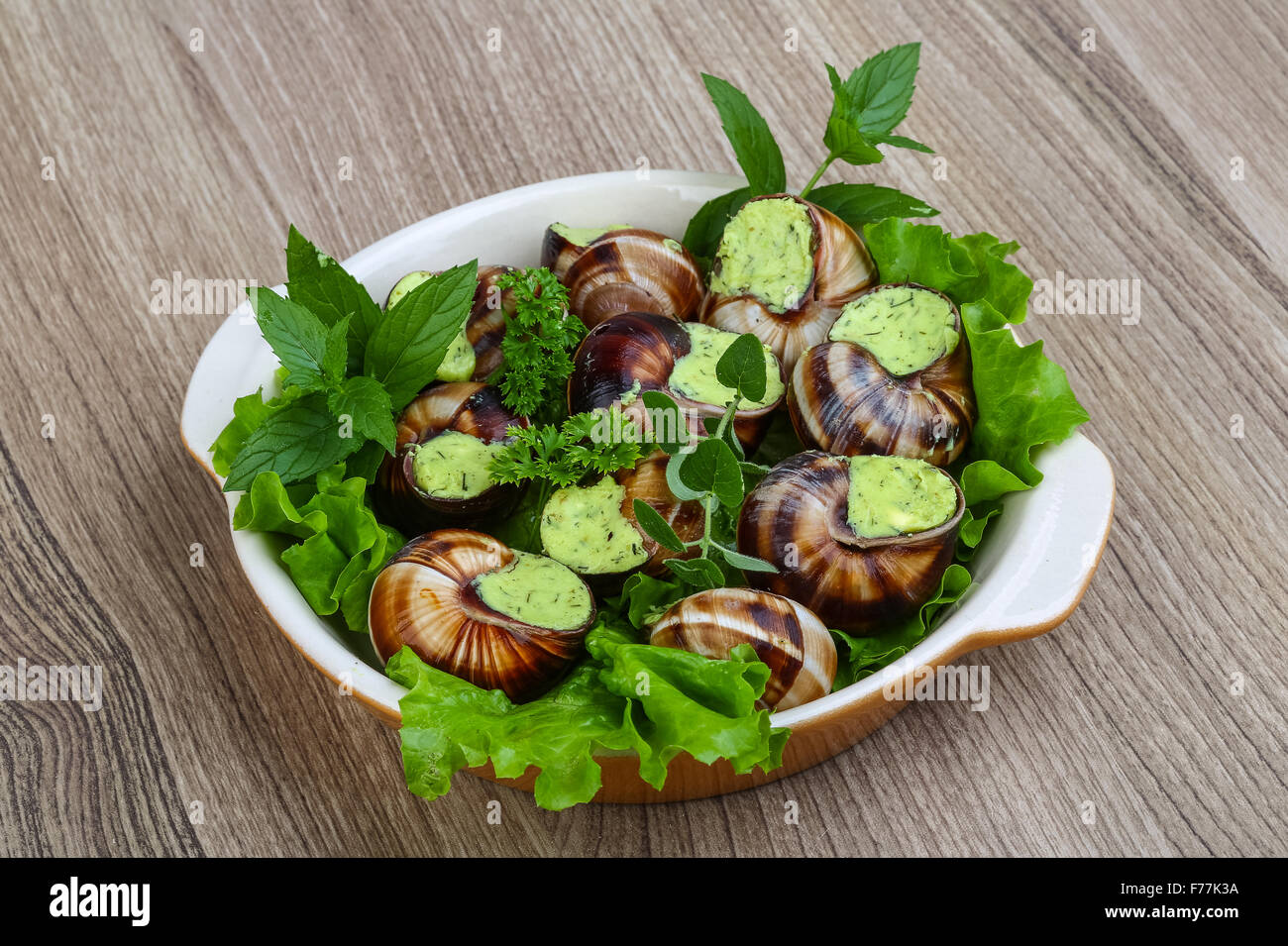 French cuisine - Escargot with butter, parsley and salat leaves Stock ...