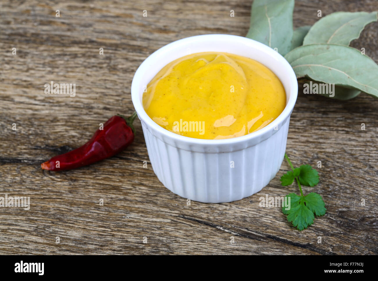 Curry sause with red pepper and coriander seeds on wood background ...