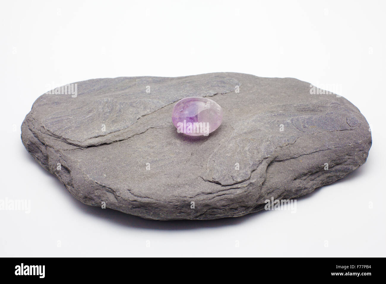 Amethyst stone on rock pebble Stock Photo - Alamy