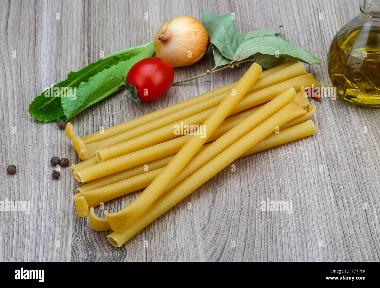 Raw italian pasta Bucatini zitoni with olive oil and herbs Stock Photo ...