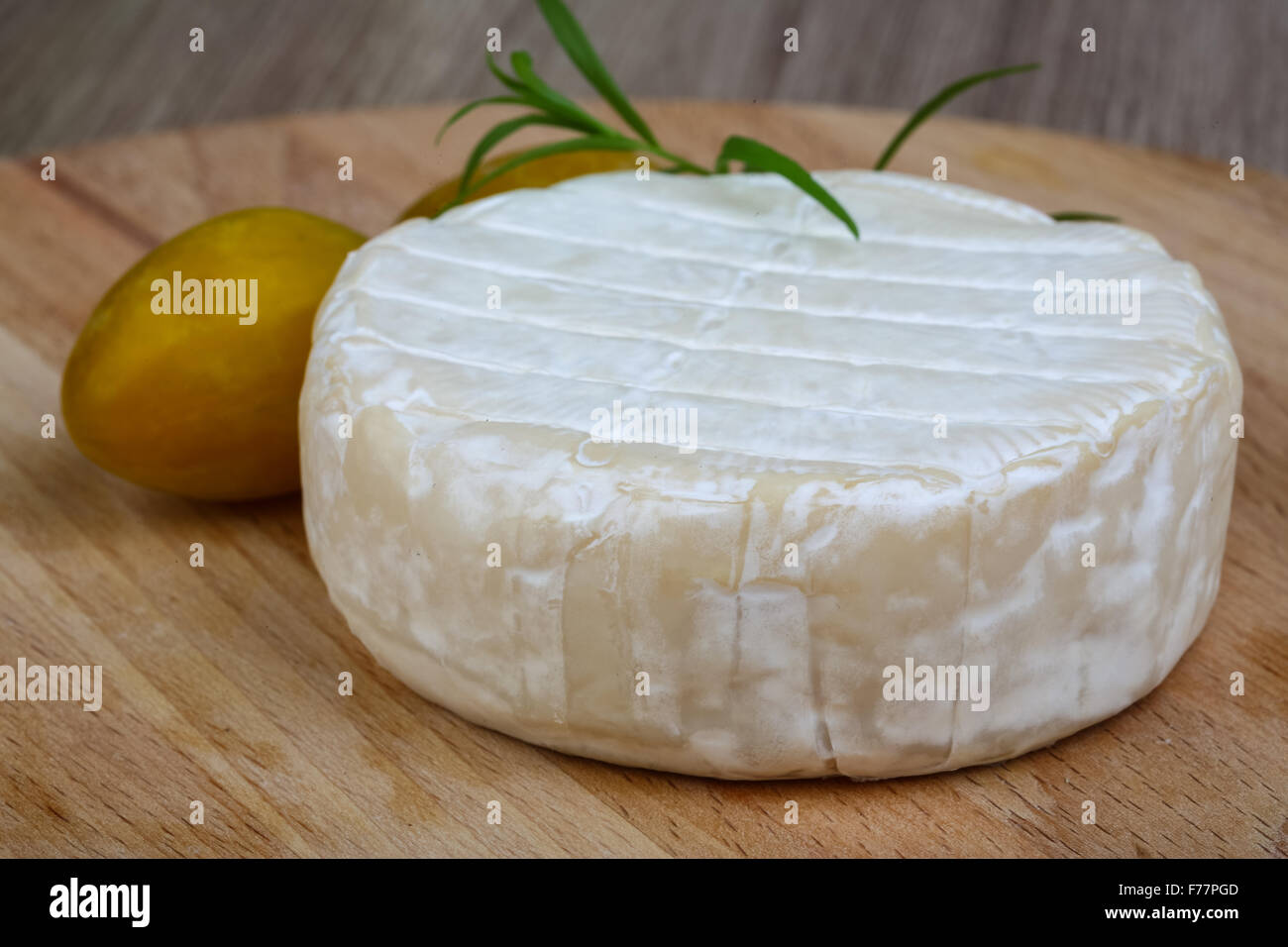 Round Brie cheese with yellow plums and estragon Stock Photo - Alamy