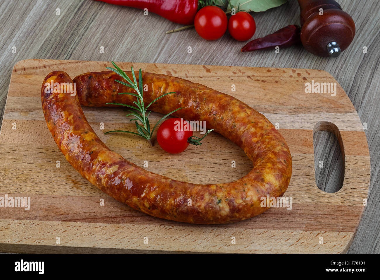 Sausage ring with rosemary and pepper on the wood background Stock ...