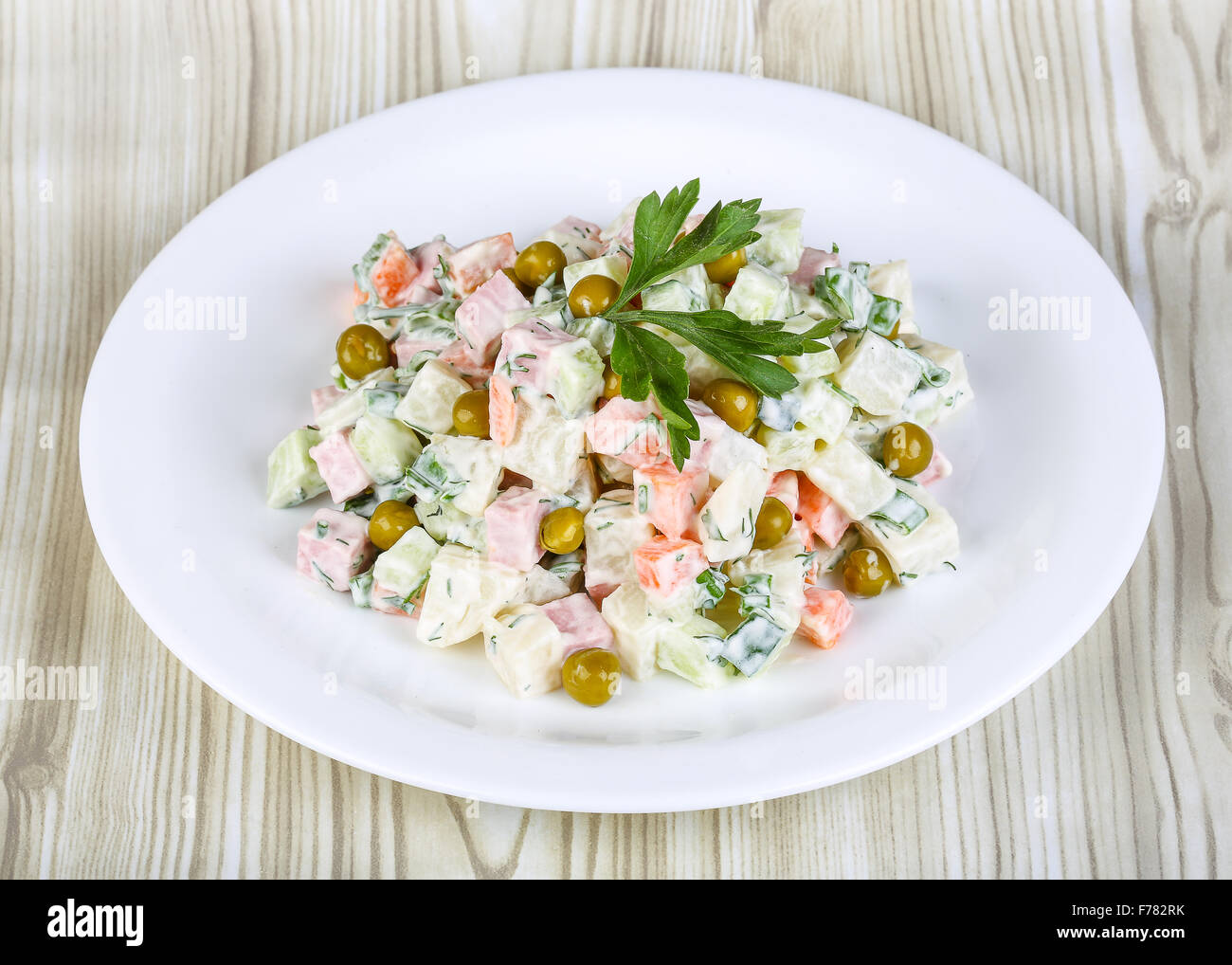 Traditional cuisine - Russian salad with parsley and sausages Stock ...