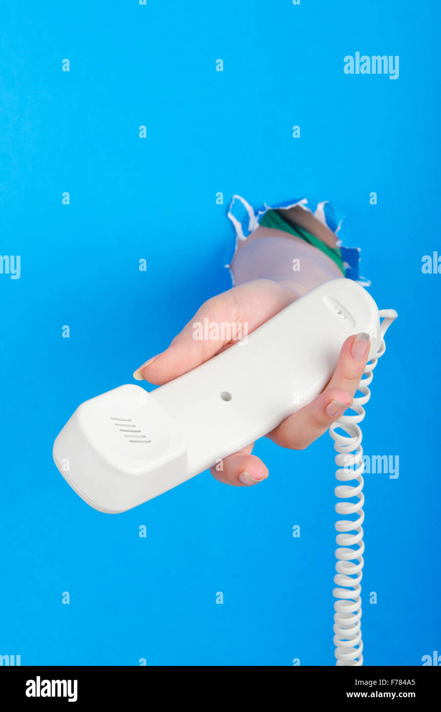 Hand with phone out of paper hole Stock Photo - Alamy