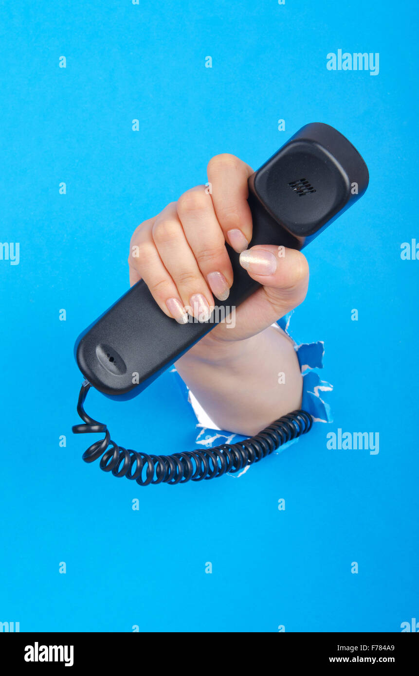 Hand with phone out of paper hole Stock Photo - Alamy