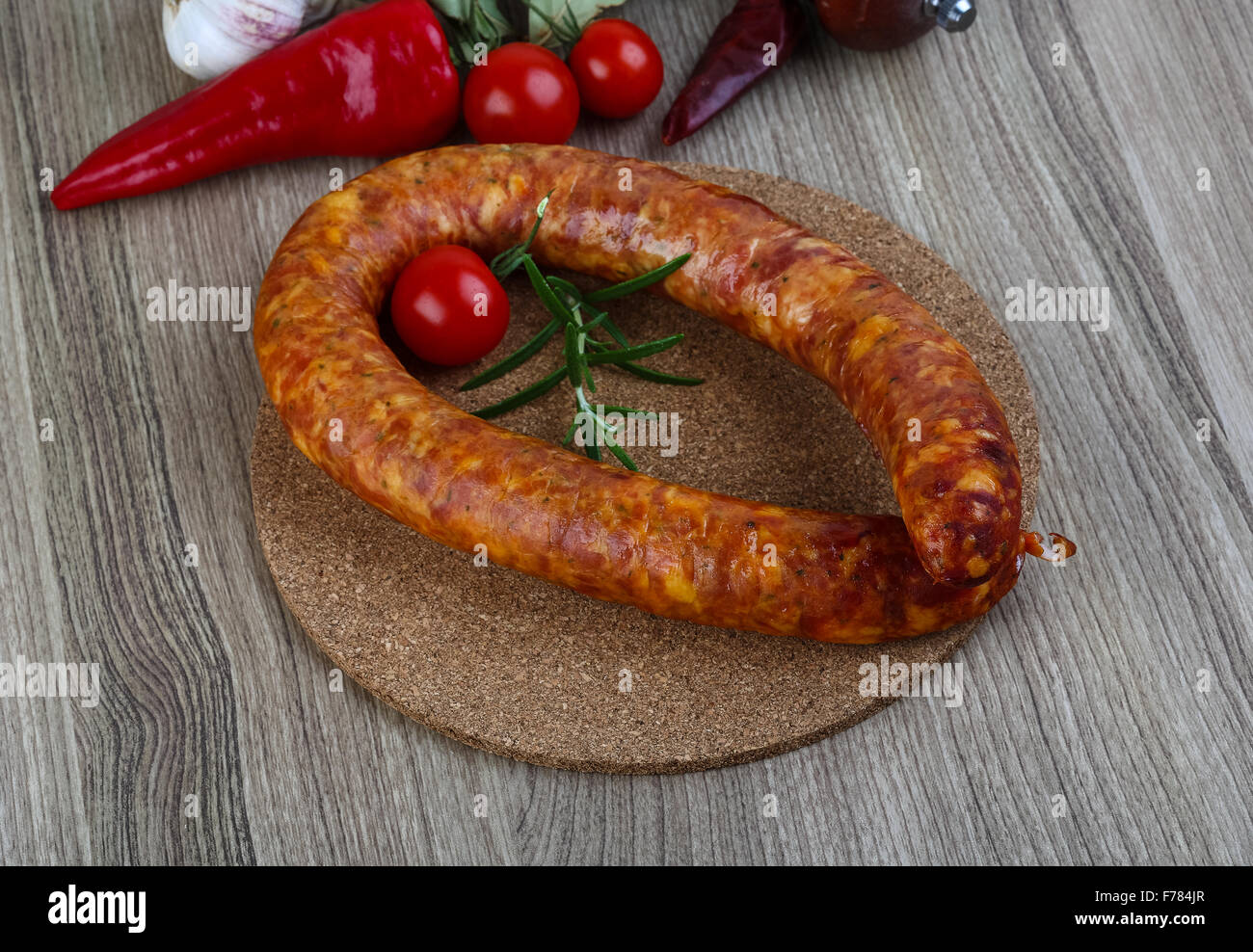 Sausage ring with rosemary and pepper on the wood background Stock ...