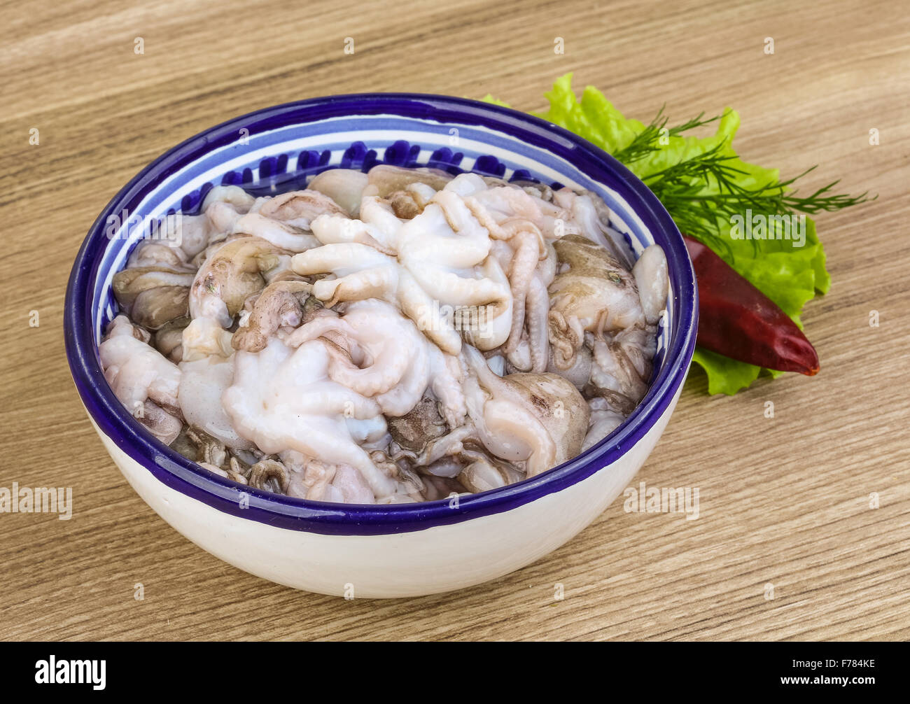 Raw baby octopus in the bowl ready for cooking Stock Photo - Alamy