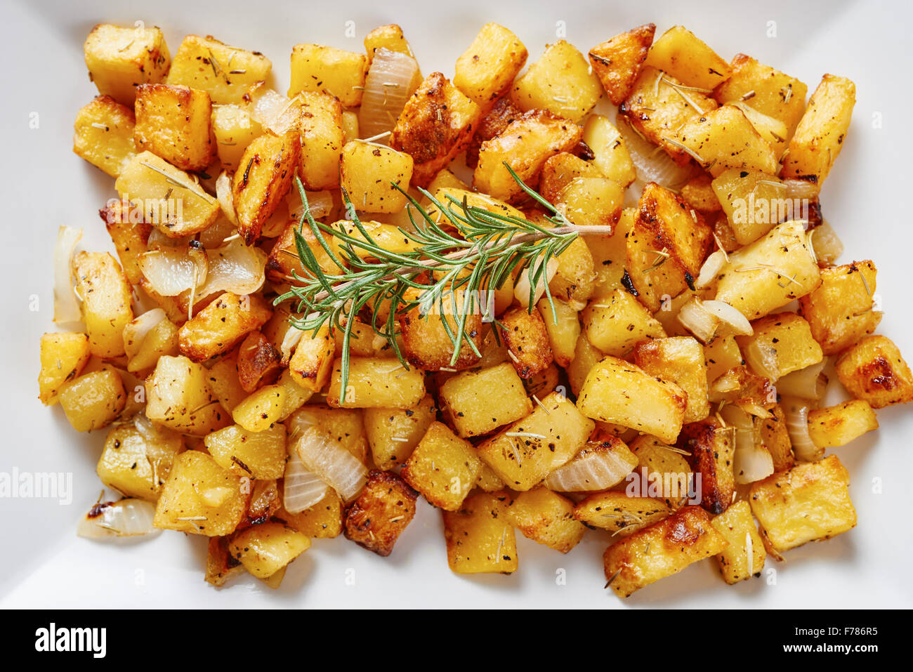 Roasted potatoes on square white plate Stock Photo - Alamy